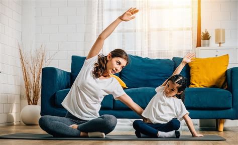 Premium Photo A Mother Teaches Her Daughter Yoga Focusing On Stretch