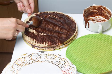 여자는 초콜릿 웨이퍼 케이크와 함께 발 랐 습 와플 삶은 연유와 초콜릿 케이크입니다 요리 과정입니다 웨이퍼 케이크 코코아와 농축 우유 요리 성분 이다 0명에 대한 스톡 사진