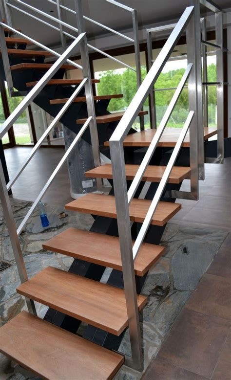 There Is A Set Of Wooden Stairs In The House With Metal Railings And