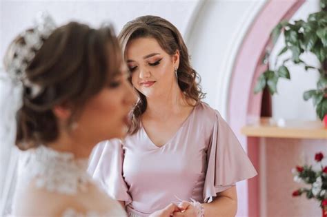 Premium Photo Morning Of The Bride The Brides Maid Of Honor Helps The Bride Lace Up Her Dress