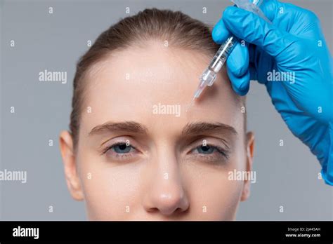 Cropped Portrait Of Young Girl Doing Cosmetology Injections Isolated Over Grey Background