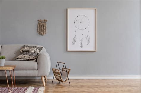 회색 소파 나무 커피 테이블 베개 회색 Macrame 포스터 프레임과 우아한 액세서리를 갖춘 거실의 미니멀하고 디자인 된 홈 인테리어 세련된 홈 장식 템플릿 공간을