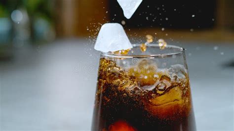 Close Up Odd Shaped Ice Cubes Fall Into A Vintage Glass Full Of Fizzy