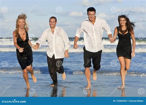 Twee Paren Die Pret Hebben Die Bij Het Strand Loopt Stock Afbeelding