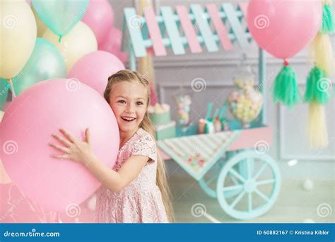 Το πορτρέτο ενός μικρού κοριτσιού χαμογελά και κρατά ένα μεγάλο μπαλόνι Στοκ Εικόνα εικόνα από