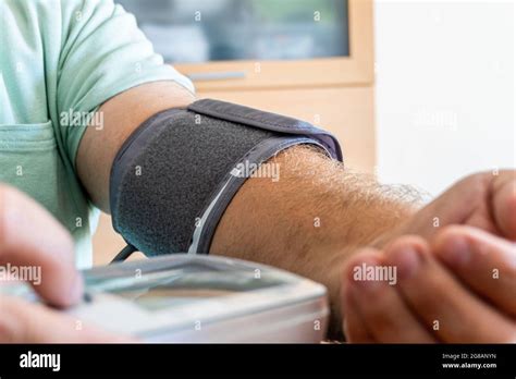 A Man S Forearm With A Sphygmomanometer Strapped On To Measure His Blood Pressure Stock Photo