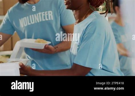 Focus On Friendly Black Woman Distributing Free Meals To The Poor And