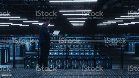 Data Center Engineer Using Laptop Computer Server Farm Cloud Computing