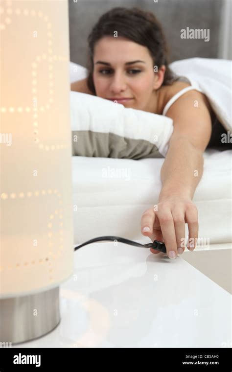 Woman Switching Off Lamp Stock Photo Alamy