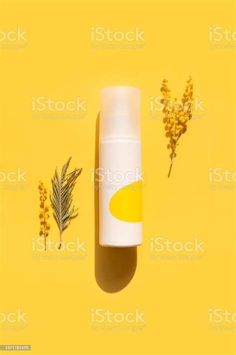 노란색 배경 평지 상단보기에 미모사 꽃이있는 깨끗한 흰색 화장품 용기 병 브랜딩 모형을 위한 빈 라벨 패키지 봄 화장품 컨셉