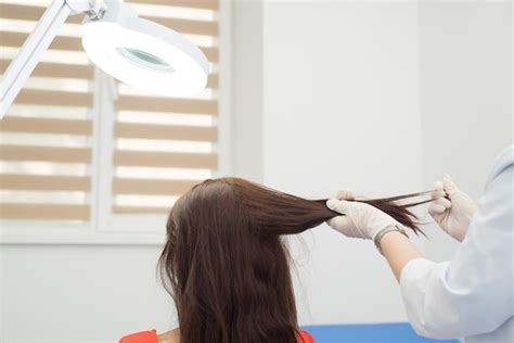 Médico dermatologista fazendo teste de perda de cabelo em paciente do