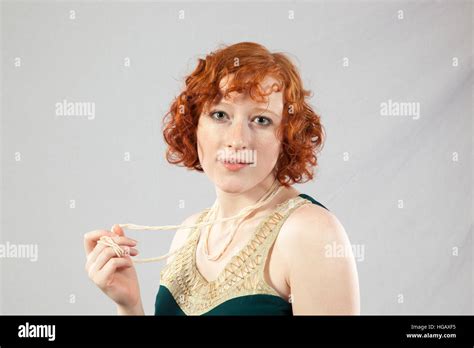 Pretty Redhead Woman In Green Dress And Pearl Looking At The Camera With A Friendly Expression