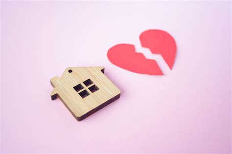 이혼 재산의 분열 빈곤과 돈 개념없음 밝은 분홍색 배경에 상한 마음을 가진 목조 주택 모기지 임대료 부동산 우울함에 대한 스톡