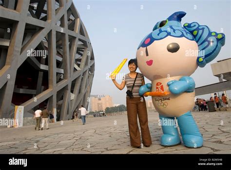 Woman Takes A Picture With Beibei Olympic Mascot In Front Of The Birds