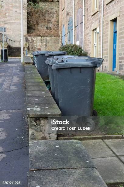 검은 쓰레기 재활용 바퀴 달린 쓰레기통은 City Street의 주거용 아파트 또는 아파트 밖에 줄지어 있습니다 0명에 대한