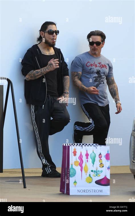 Dave Navarro And A Friend Smoking A Cigarette While Checking The Brand