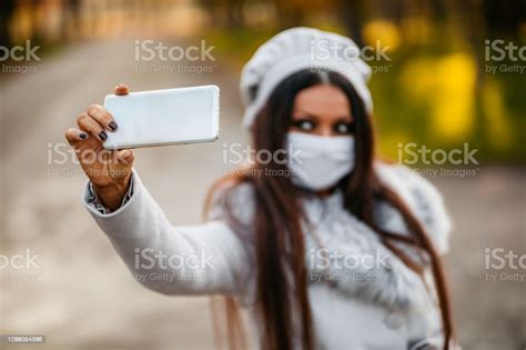 공원에서 셀카를 만드는 얼굴 마스크를 가진 우아한 여성 10월에 대한 스톡 사진 및 기타 이미지 10월 11월 9월