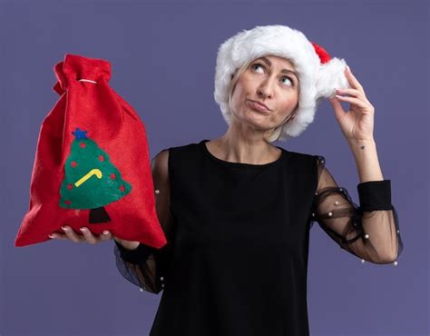 Mulher Loira De Meia Idade Confusa Usando Um Chapéu De Natal Segurando
