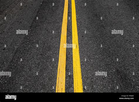 Yellow Double Dividing Lines Highway Road Marking On Dark Asphalt