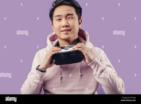 Augmented Reality And Virtual Reality Positive Chinese Young Hipster Taking Off Virtual Reality