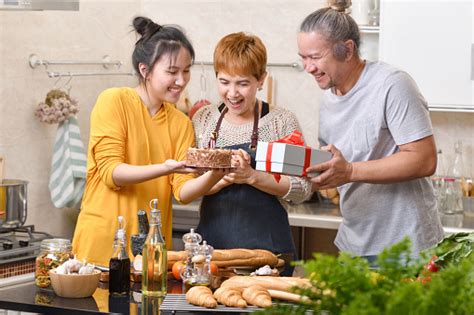 케이크와 선물과 함께 생일 파티를 축하하는 부엌에서 어머니 아버지와 딸의 행복한 가족 3 명에 대한 스톡 사진 및 기타 이미지