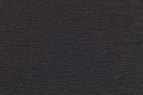 오래 된 회색 종이 근접 촬영의 질감입니다 고밀도 판지의 구조 검정색 배경 프리미엄 사진