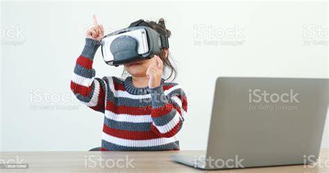 홈 안경의 책상에 앉아 Vr을 입은 어린 소녀는 가상 글로벌 인터넷 연결 메타버스 게임을 위한 Vr 헤드셋을 착용한 흰색 옷을