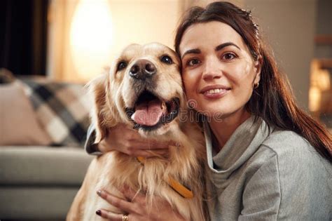 Close Up View Portrait Woman Is With Golden Retriever Dog At Home