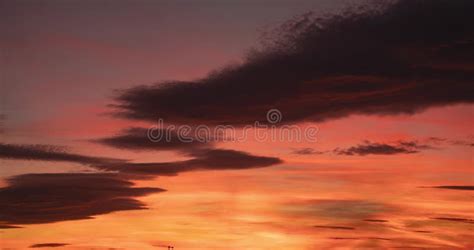 Time Lapse Of A Reddish Sky With Moving Clouds At Dusk Until Night Falls And Darkness With