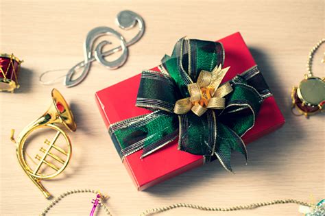 하나의 아름 다운 빨간 선물 상자 나무 보드에 녹색 리본 세트로 포장의 클로즈업 복사 공간에 대 한 초점 인공 작은 음악 장식품 장식 계절에 대한 스톡 사진 및 기타 이미지