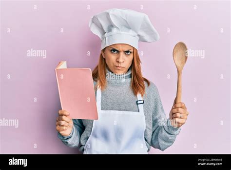 Hispanic Young Chef Woman Reading Recipes Book Skeptic And Nervous