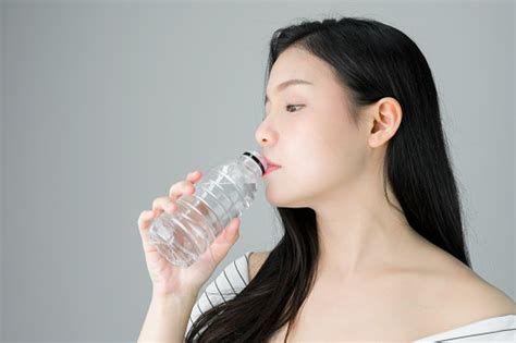 여자 피부 아름다움과 건강 깨끗 한 병에서 식용 수 피부는 부드럽고 아름 다운 흰색 바탕에 건강 한 여자의 개념입니다 건강한