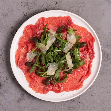 Premium Photo Marbled Beef Carpaccio With Arugula Capers And Parmesan