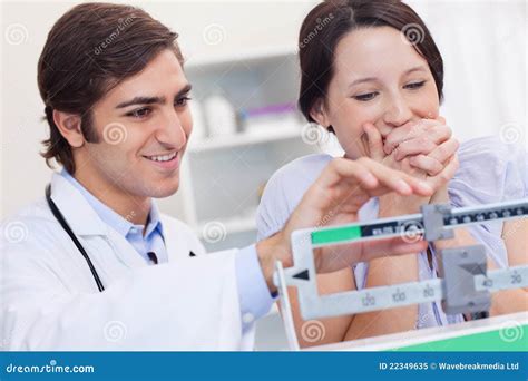 Doctor Adjusting Scale For Excited Patient Stock Image Image Of