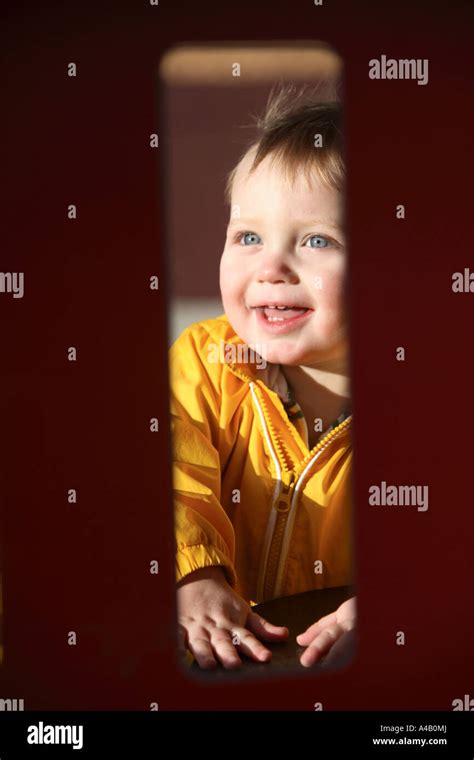 One Year Old Boy Photographed Through A Rectangle Hole At A Park Stock