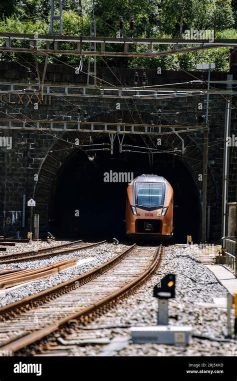 A View Of A Train Emerging From A Tunnel As It Travels Along The Tracks
