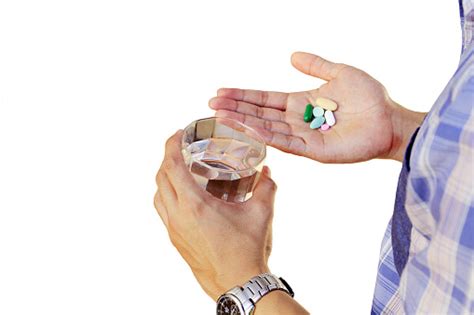 흰색 배경 제약의 약 건강에 대 한 컨테이너에 치료에 절연 물 잔으로 약을 복용 한 남자가 있다 항생제 진통제 근접 촬영입니다