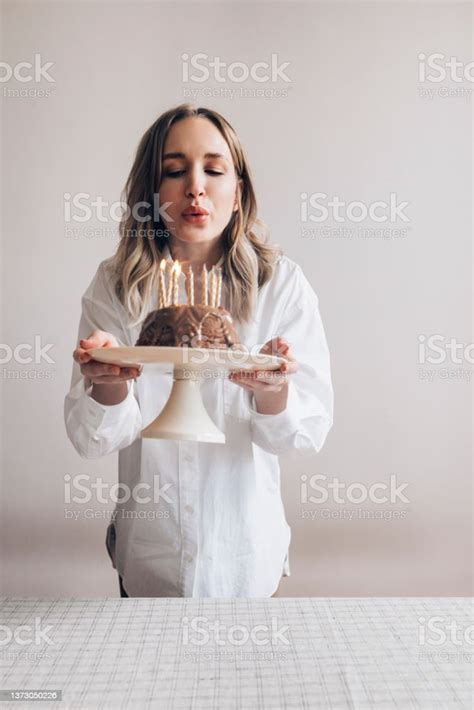 생일 축하해요 아름다운 백인 여성 에 A 흰색 셔츠 불고 생일 촛불 에 A Gugelhupf 케이크 생일 케이크에 대한 스톡