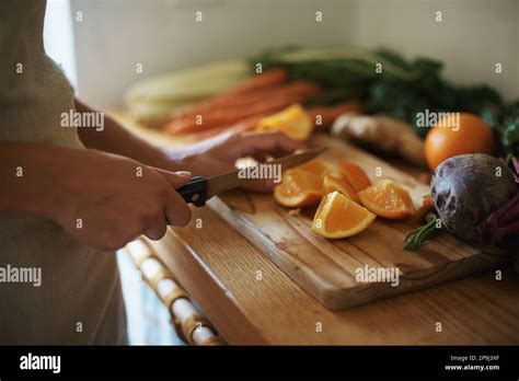 Getting A Daily Dose Of Vitamin C A Woman Slicing Oranges On A