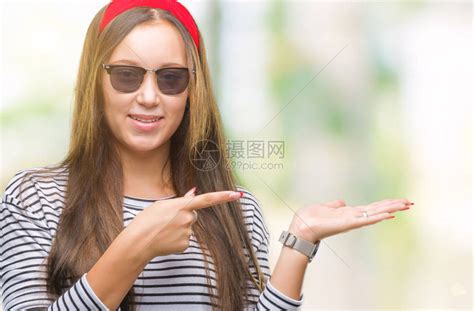 身戴墨镜的年轻美丽的天主教女青年在孤立的背景中惊异地微笑着摄影机高清图片下载 正版图片505563842 摄图网