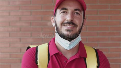 Portrait Of Hispanic Delivery Man Taking Off Protective Face Mask And