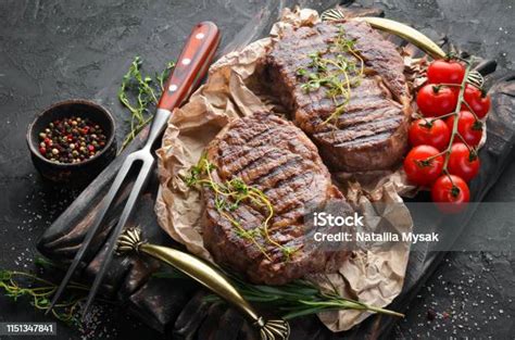리 베야 쇠고기 스테이크 허브와 향신료를 어두운 테이블에 구워 냅니다 평면도 텍스트를 위한 여유 공간 0명에 대한 스톡 사진 및