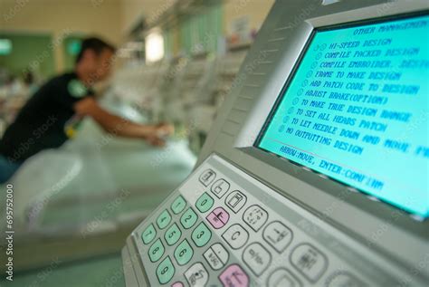 Close Up Photo Of Monitor Display And Buttons Of Embroidery Machine With Blurred Background Of