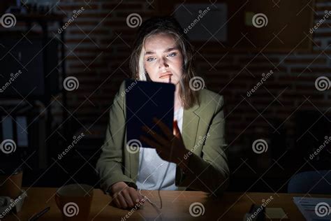 Blonde Caucasian Woman Working At The Office At Night Looking Sleepy