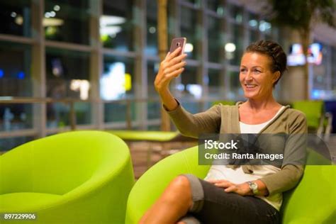성숙한 관광 여자 공항 비행기 기다리고 하 고 Selfie 그림을 복용 하는 동안 휴대 전화를 사용 하 여 45 49세에 대한 스톡 사진 및 기타 이미지 Istock