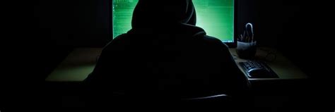Premium Photo Hacker In A Hoodie Sitting At His Computer