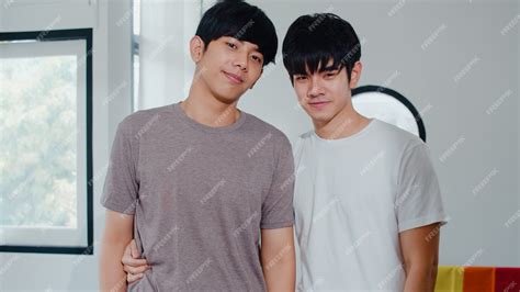세로 젊은 아시아 게이 커플 집에서 웃 고 행복 한 느낌 아시아 Lgbtq 남자는 아침에 집에서 거실에서 포옹하면서 카메라를