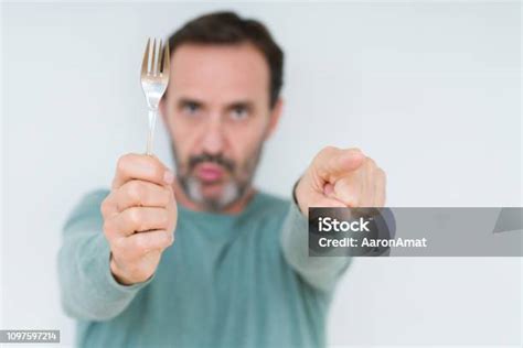 당신에 게 카메라를 손가락으로 가리키는 격리 된 배경 위에 수석 남자 지주 실버 포크 손 기호 앞에서 긍정적이 고 자신감 제스처
