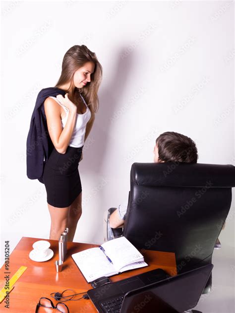 Girl In A Suit Stands Next To A Desk At The Table Sat The Chief Sexual Harassment In The