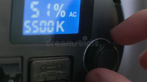 Man Turning On An Led Video Light And Adjusting Its Brightness Close